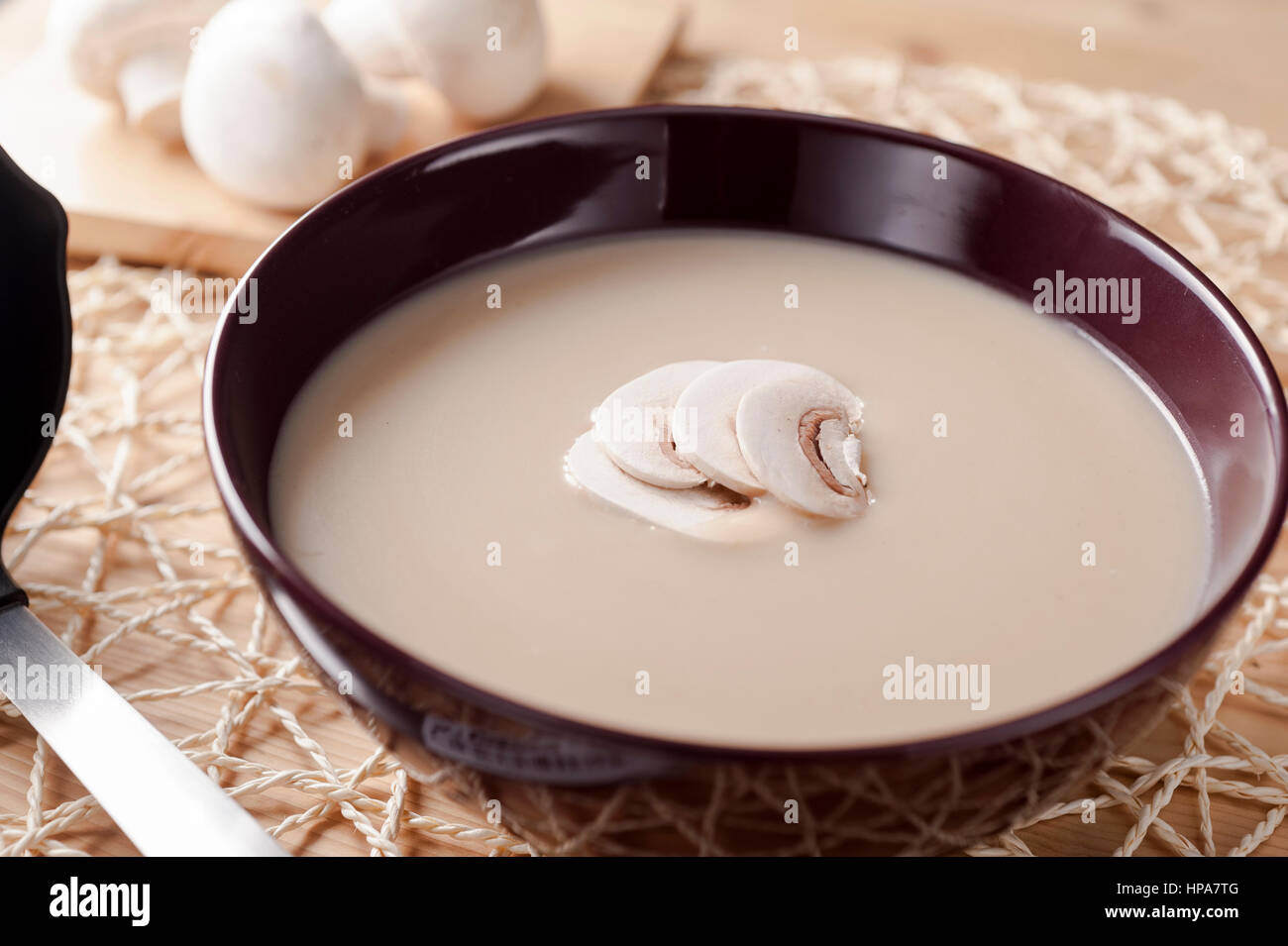 champignon mushroom soup in a bowl served with raw champignon slices ...
