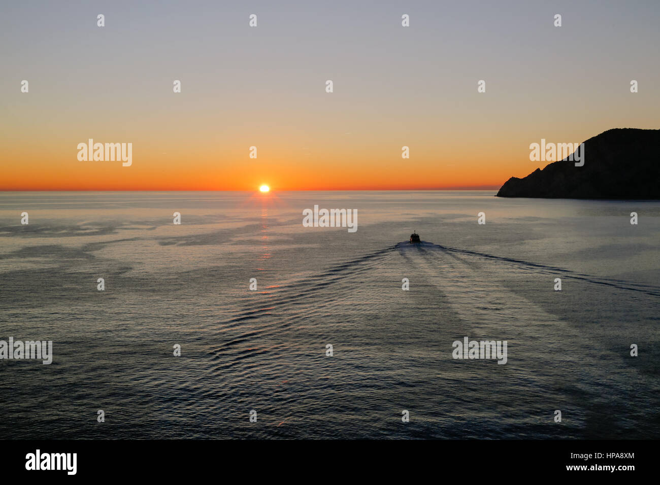 A boat heading into the sunset in Mediterranean Sea heading off the ...