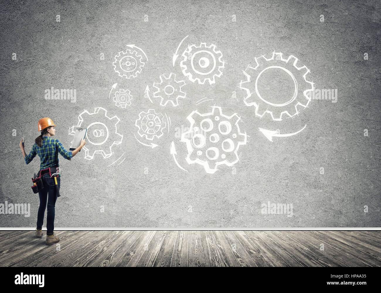 Back view of engineer woman in hardhat and sketched concept of teamwork ...