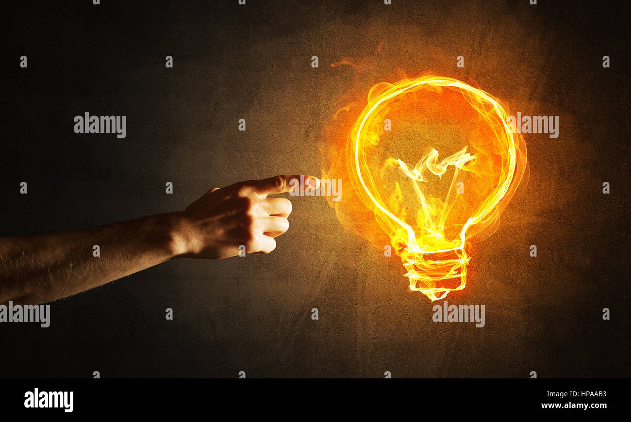 Close of man hand showing at glowing fire light bulb icon Stock Photo ...