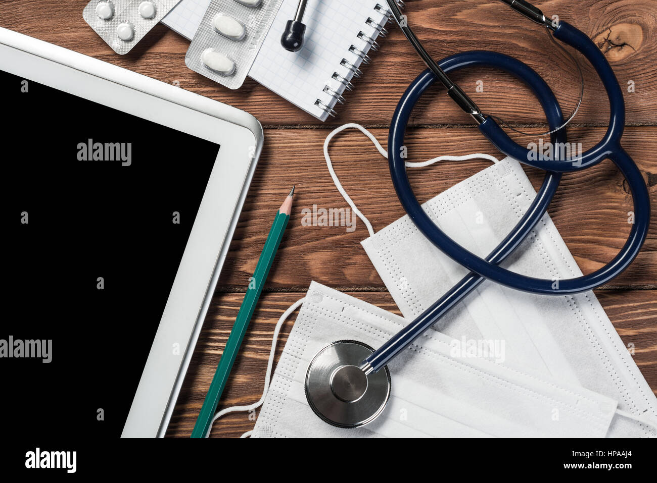 Doctors wooden table with white tablet and stethoscope Stock Photo - Alamy