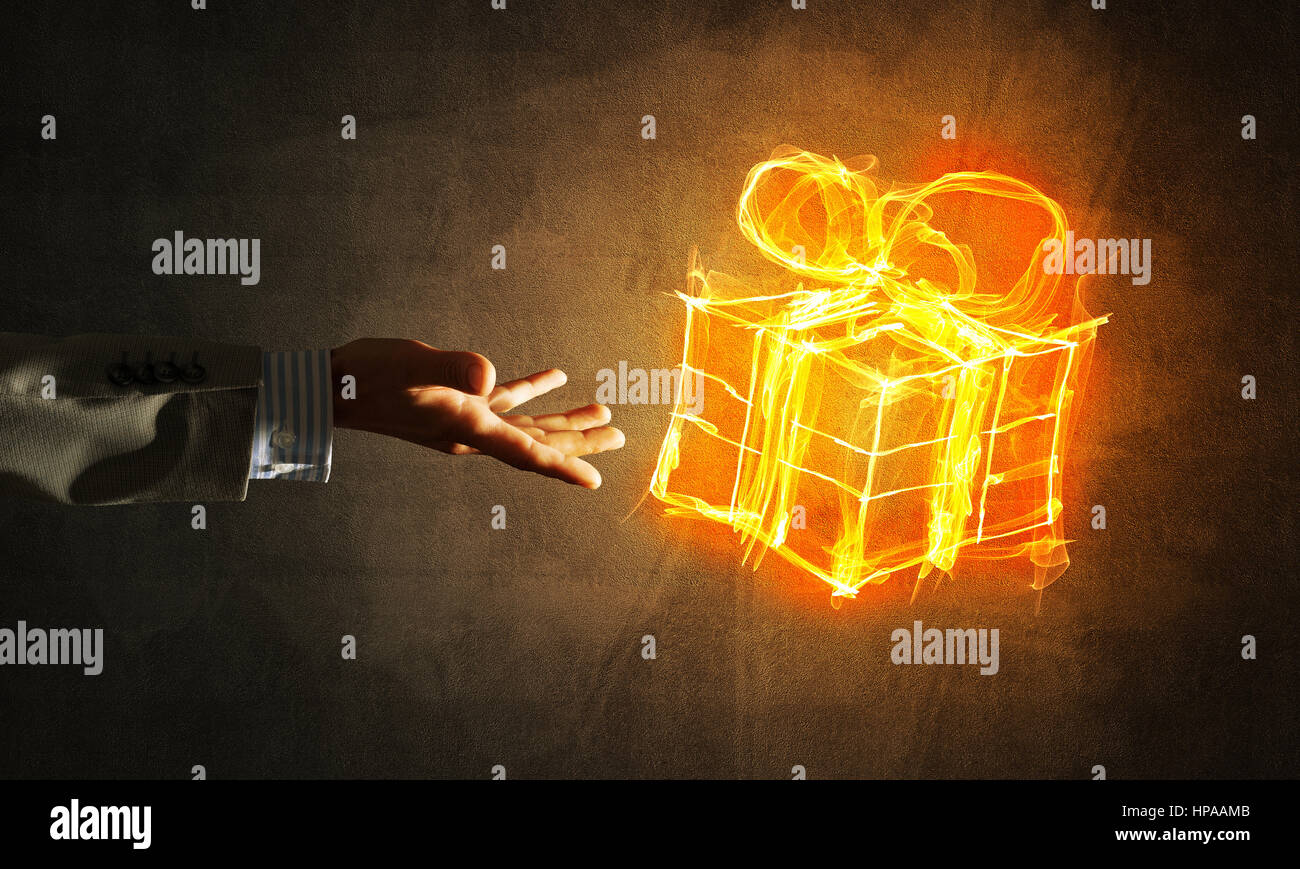 Businessman hand pointing at glowing fire gift box icon on dark ...