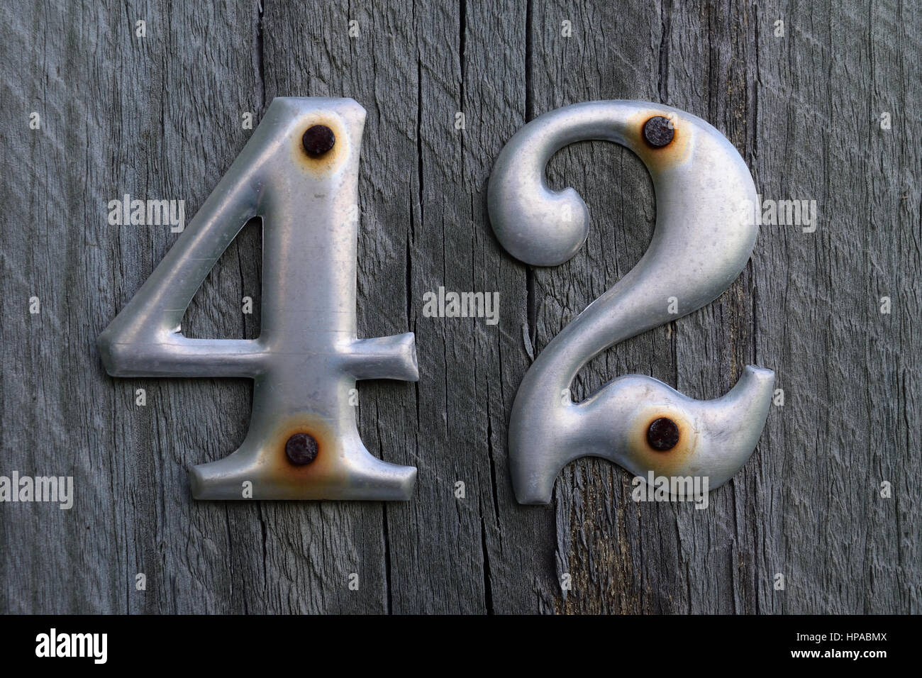 Metal Number 42 Nailed to Weathered Wood Post Stock Photo - Alamy