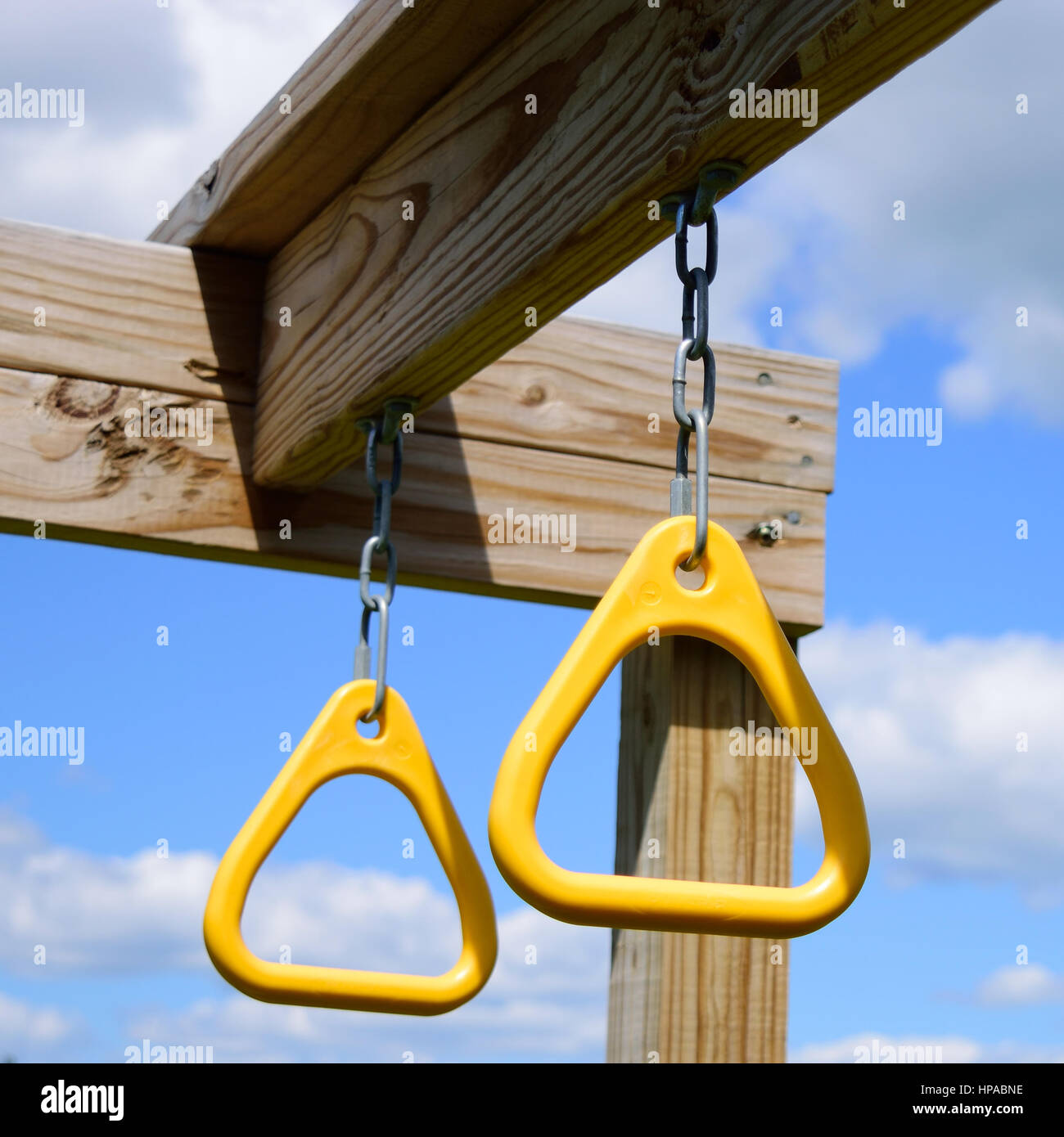 Yellow Monkey Bar Rings Against Blue Sky Stock Photo - Alamy