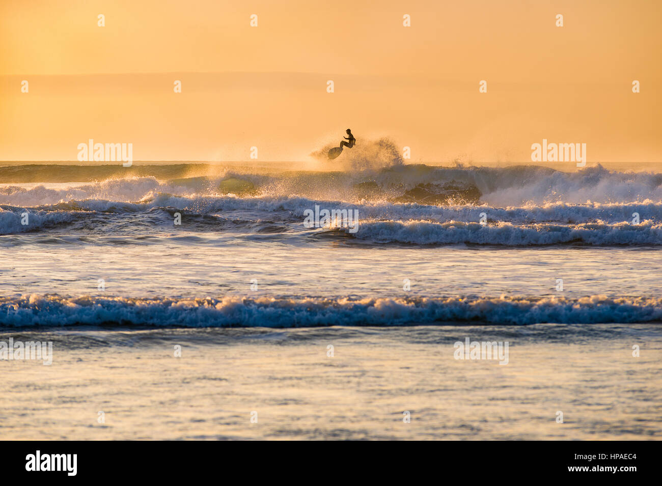 Surfer in action and catching some air after hitting the crest of a ...