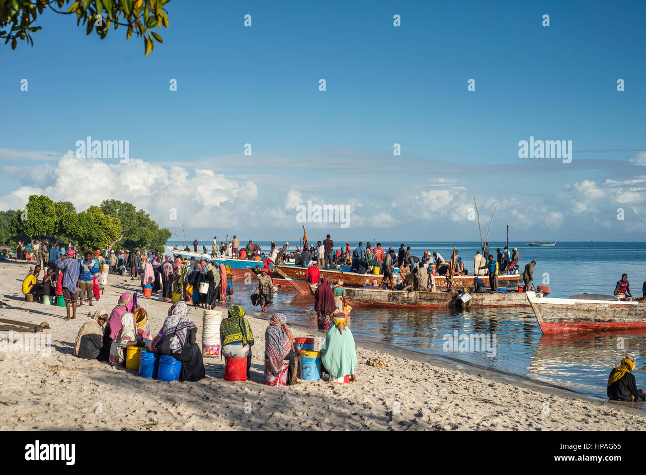 People wait for boats with fish in Mkokotoni village, Zanzibar. These ...