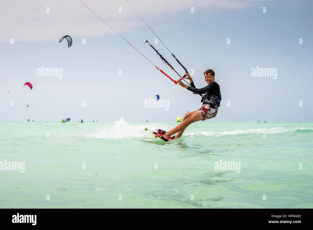 A boy flying kite on a beach of Paje, Zanzibar, Tanzania. Paje is a ...