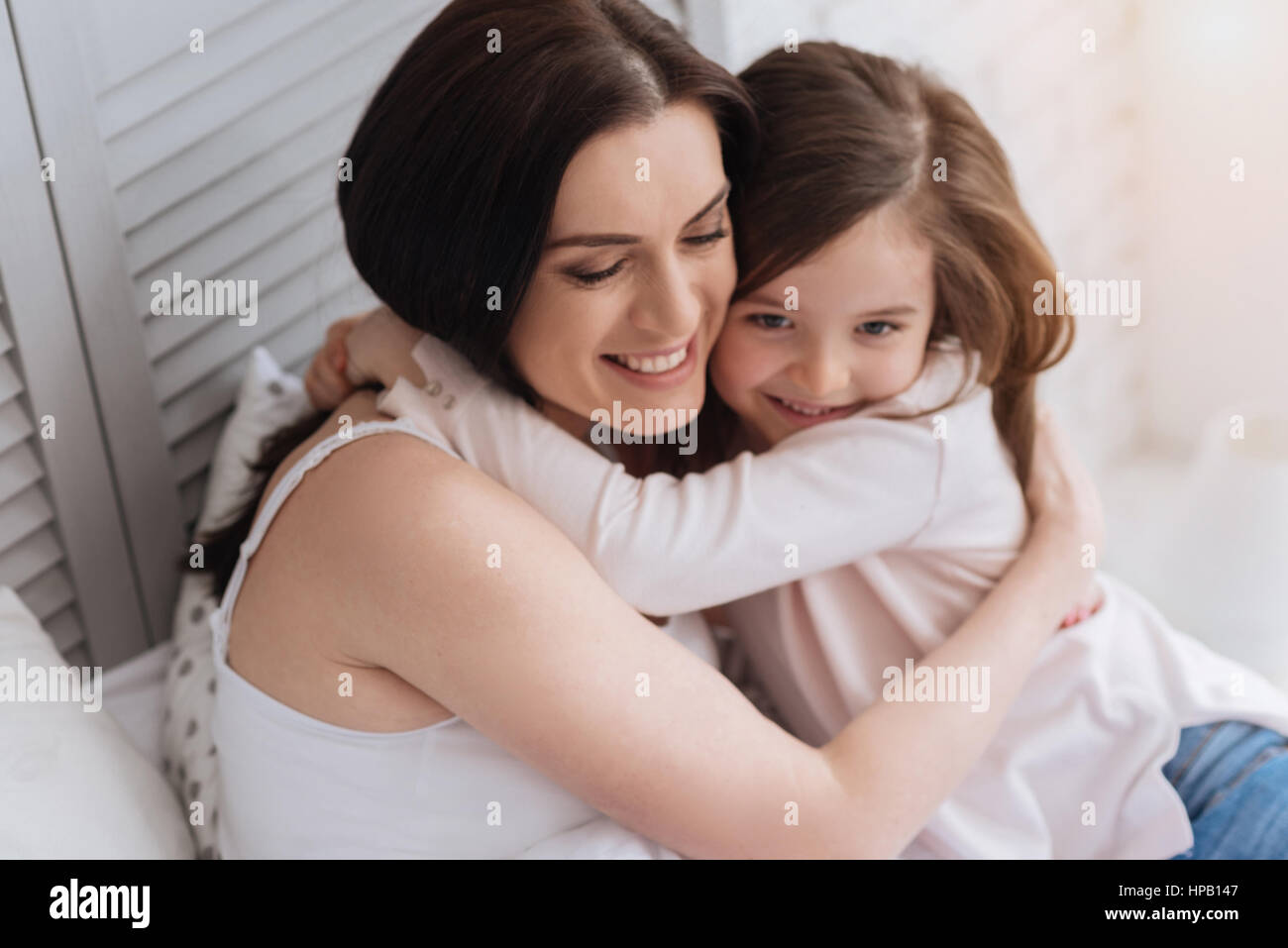 Mother and daughter. Happy attractive delighted woman lying in her bed ...