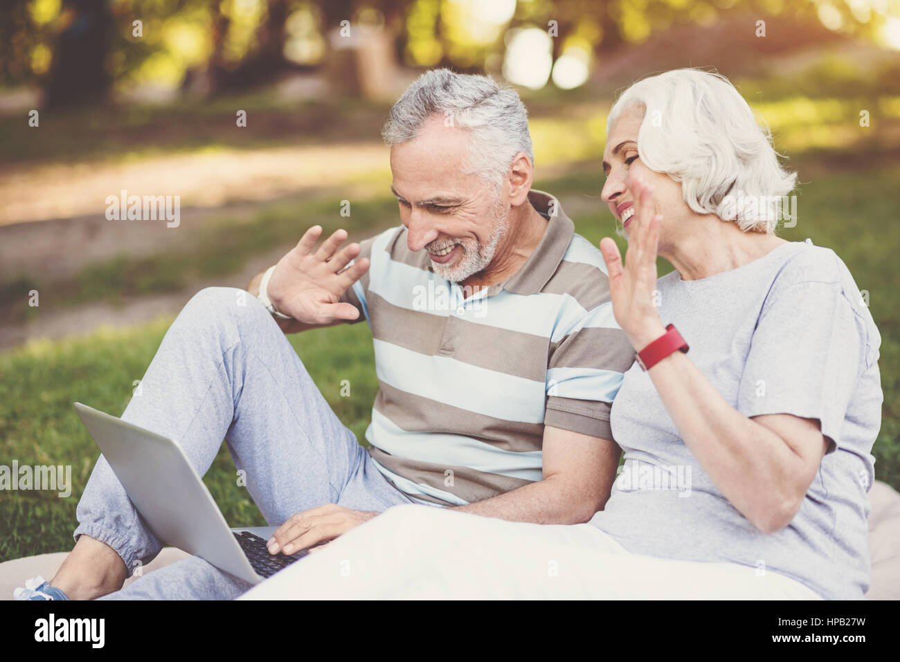Distance call. Positive delighted senior couple looking at the laptop ...