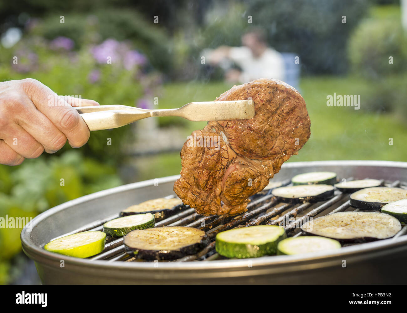 Gegrilltes Fleisch wird ueber Grill gehalten Stock Photo - Alamy