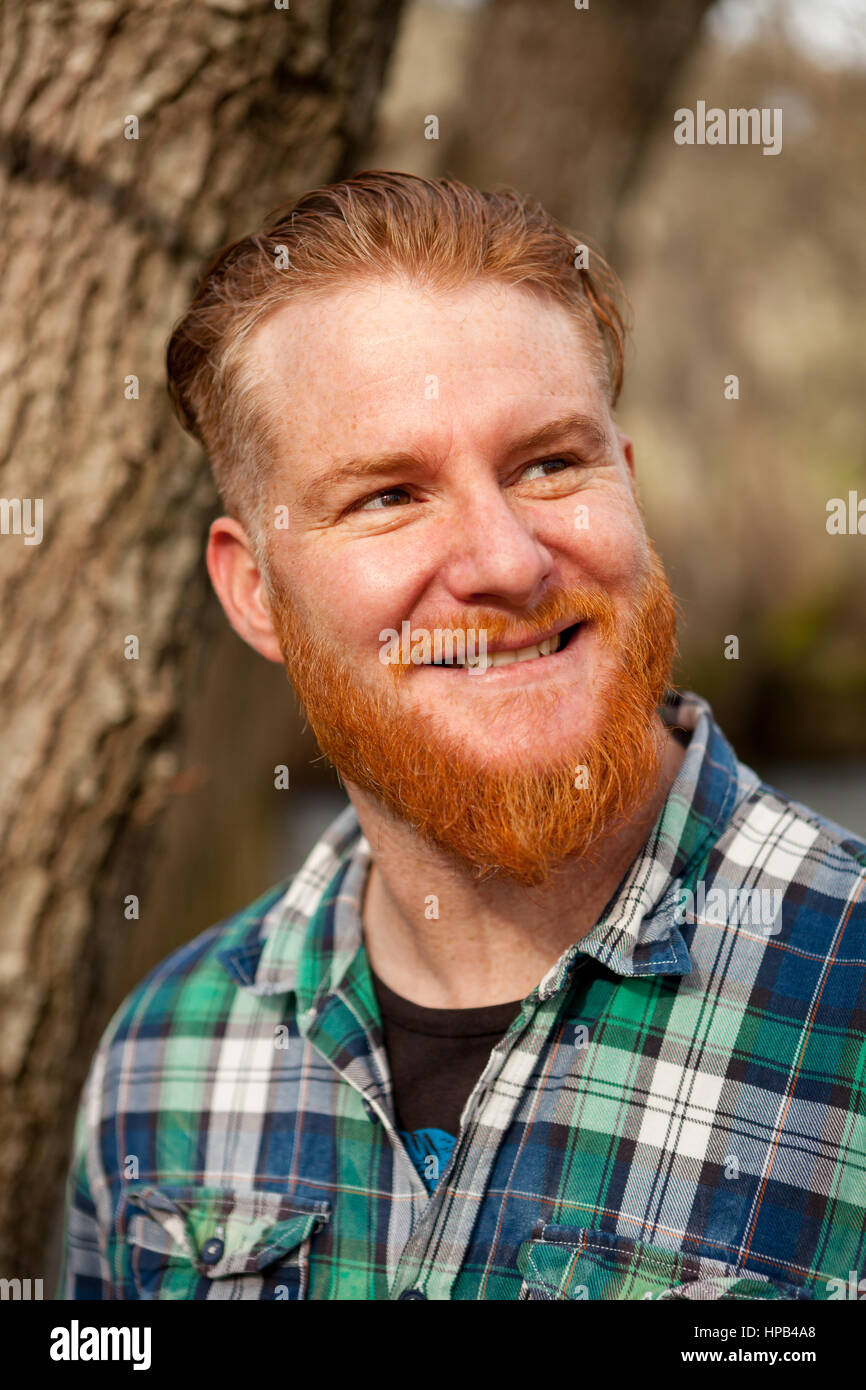 Portrait of red haired man with plaid shirt and long beard in the ...