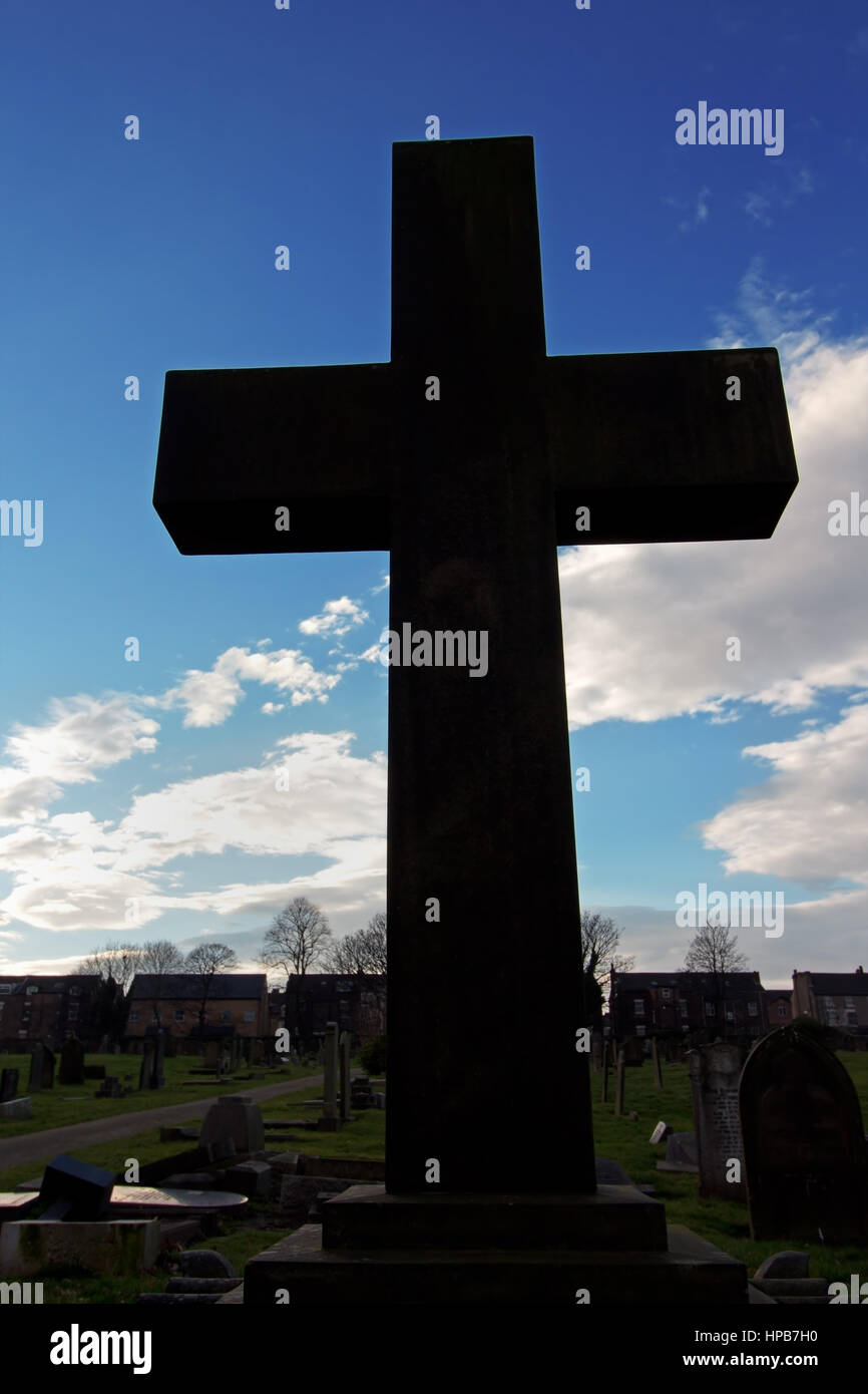 Graveyard cross in silhouette against a blue sky Stock Photo - Alamy