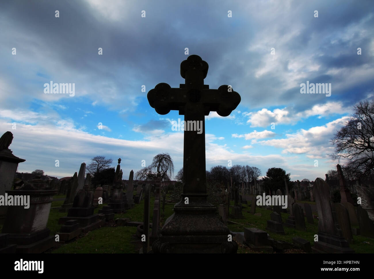 Graveyard cross in silhouette against a blue sky Stock Photo - Alamy