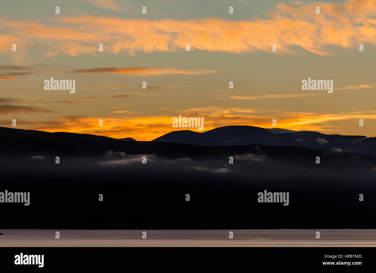 Sunset, nightfall in the Nordic mountains. Lake this side and mountain ...