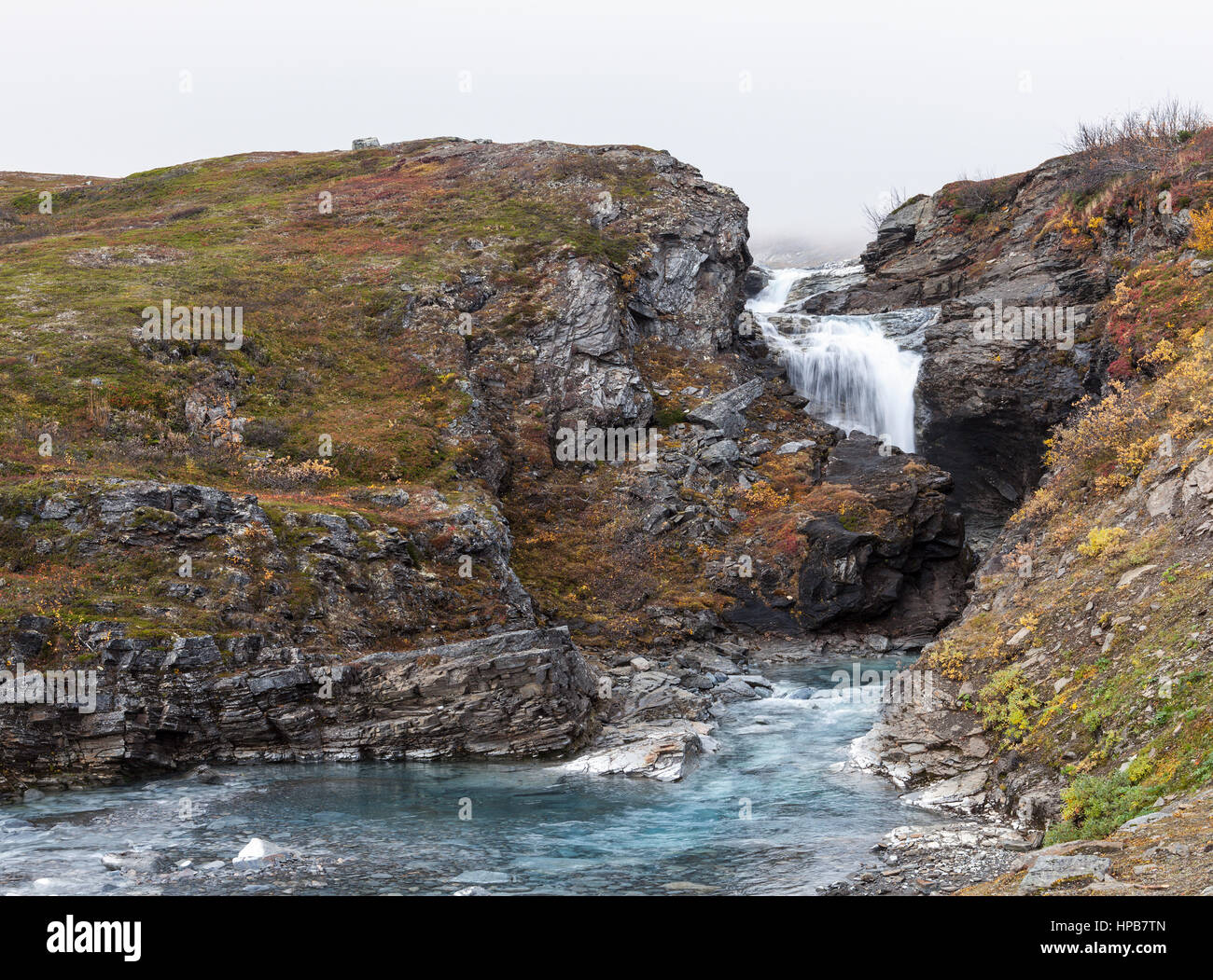 September by a short river up north. Waterfall in a river. View from ...