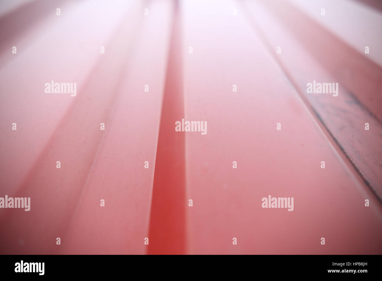 Red ribbed container wall close up. Red shiny background. Straight rows ...