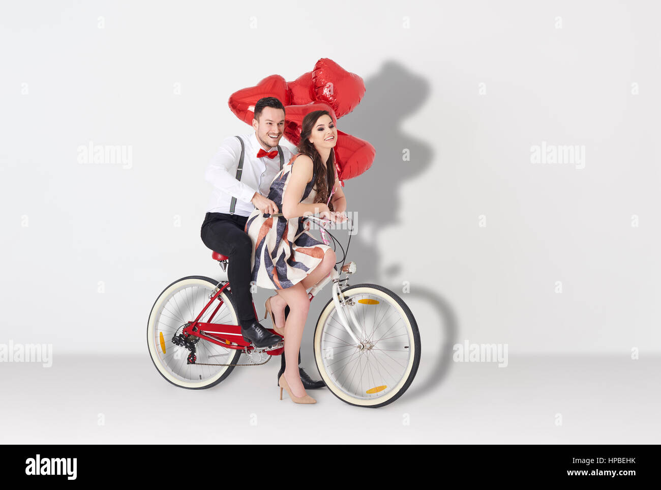 Young couple riding on the bike Stock Photo - Alamy