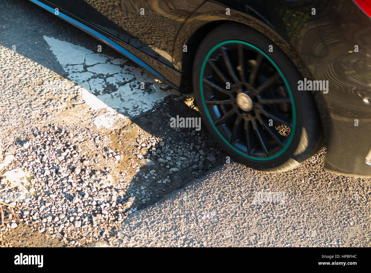Car wheel driving over a pot hole / Pothole / holes / potholes where ...