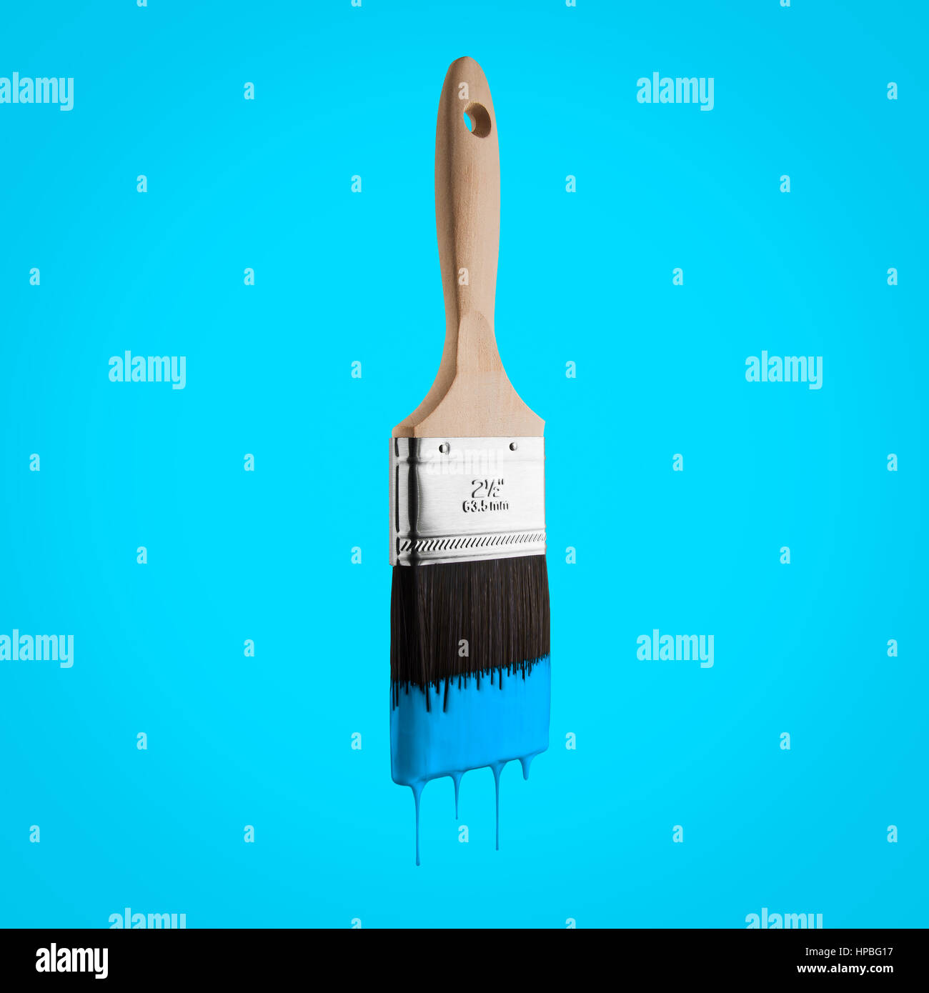 Paintbrush loaded with blue sky color dripping off the bristles, on ...