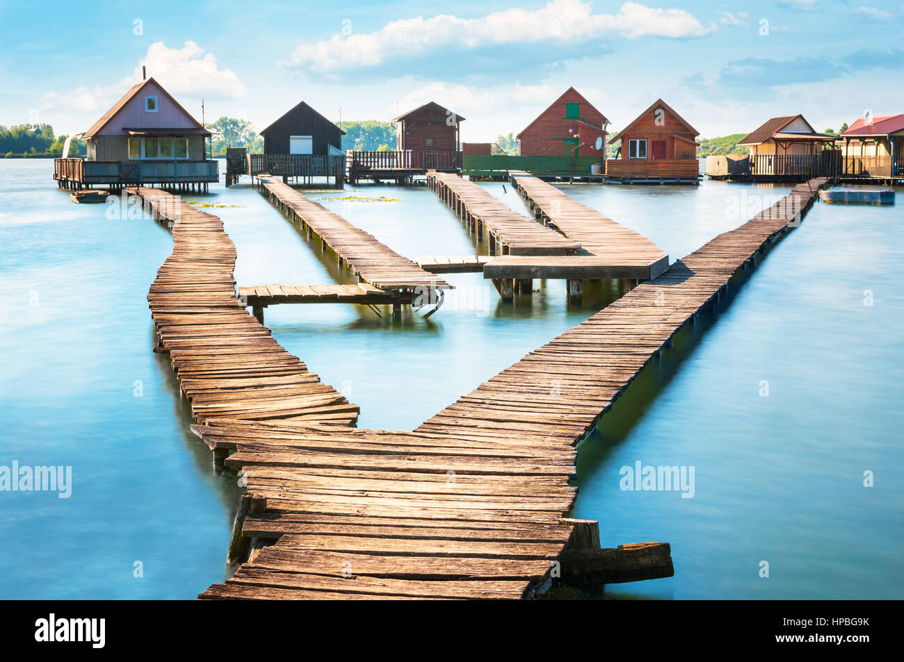 Old colorful fishing huts on a lake Stock Photo - Alamy