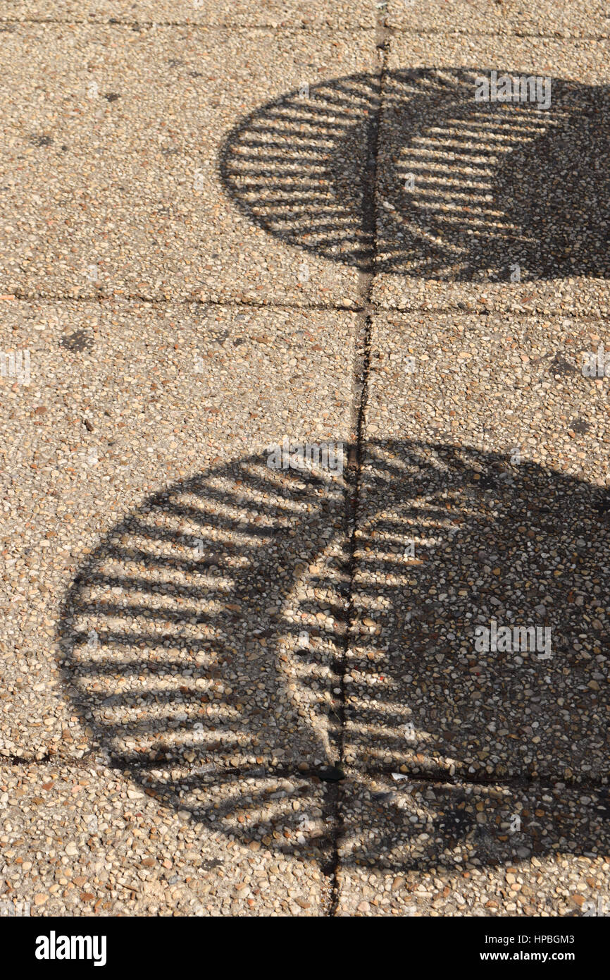 Curved shadows on a sidewalk Stock Photo - Alamy