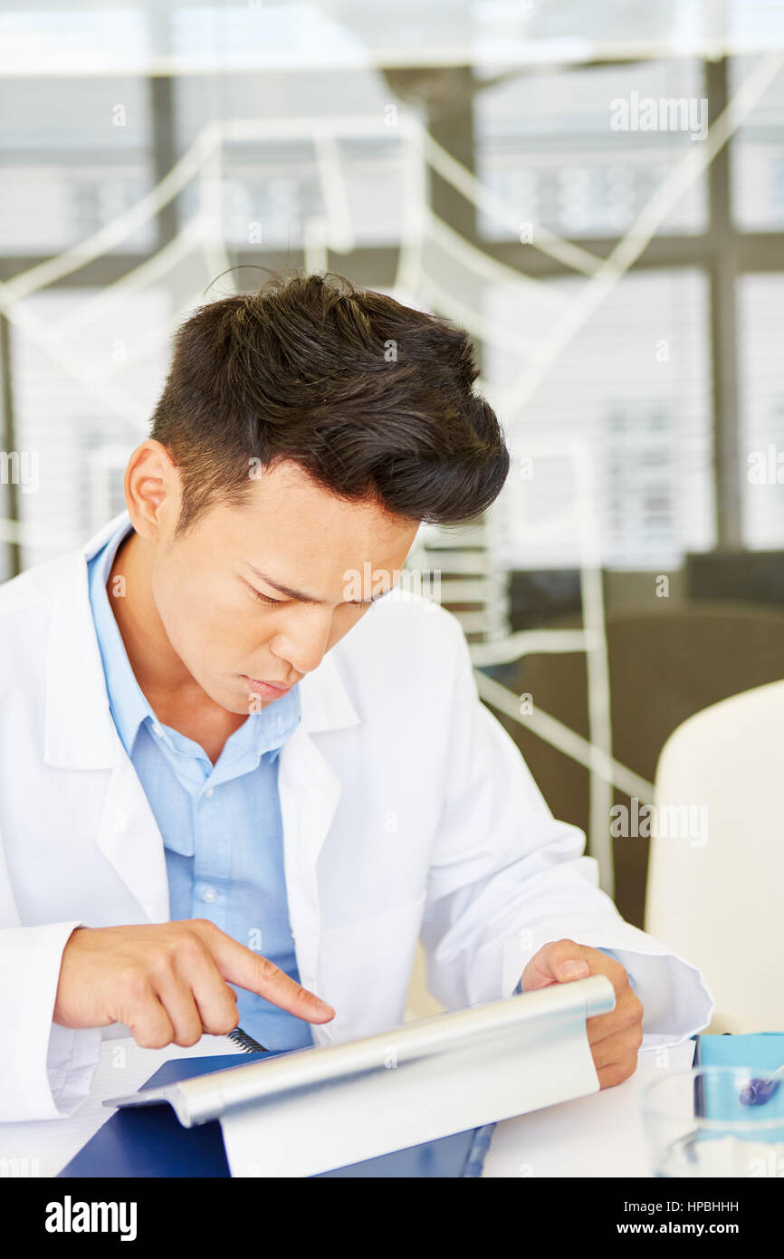 Asian man as doctor reaserching with tablet computer in clinic Stock ...