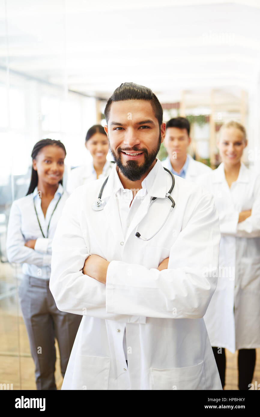 Confident man as doctor with successful team in hospital Stock Photo ...