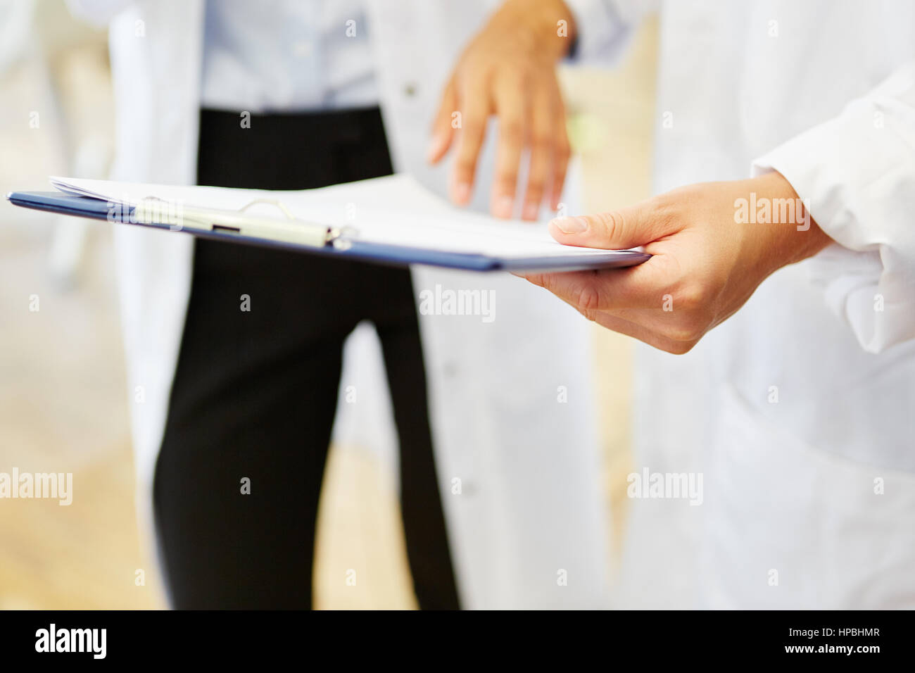 Doctor controls patient record with checklist on clipboard Stock Photo ...