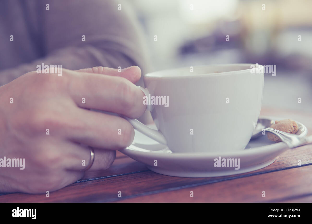Man's hand holding a cup of coffee Close-up a cup of coffee on old ...
