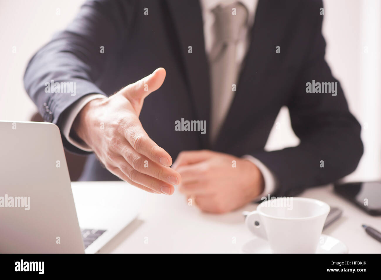 Businessman offering handshake Stock Photo - Alamy