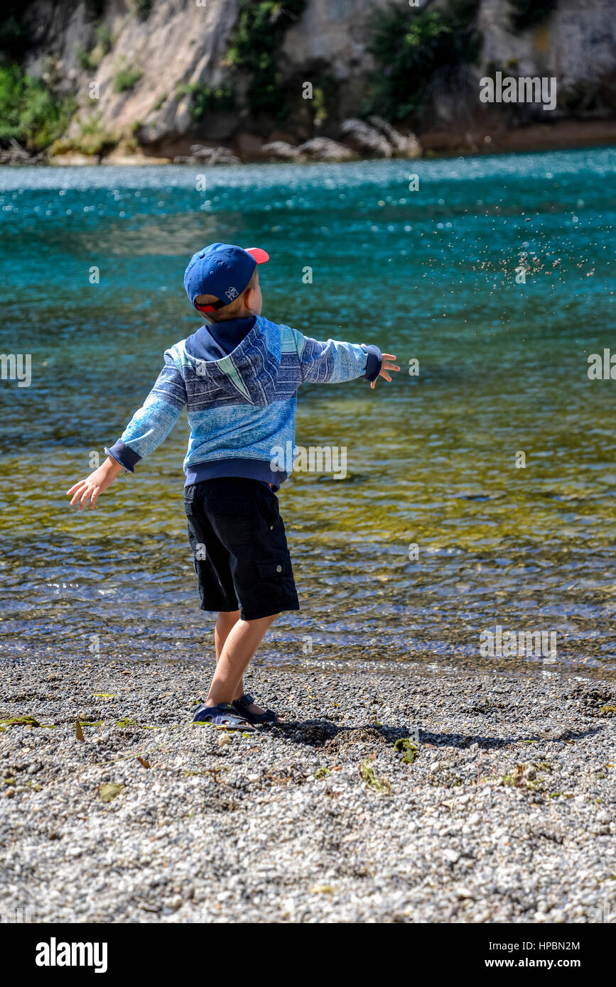 Boy throwing stone into water High Resolution Stock Photography and ...