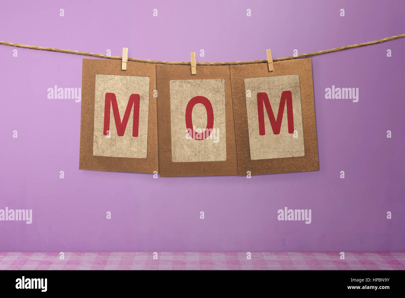 Mom word shape hanging with clothespin against pink background Stock ...