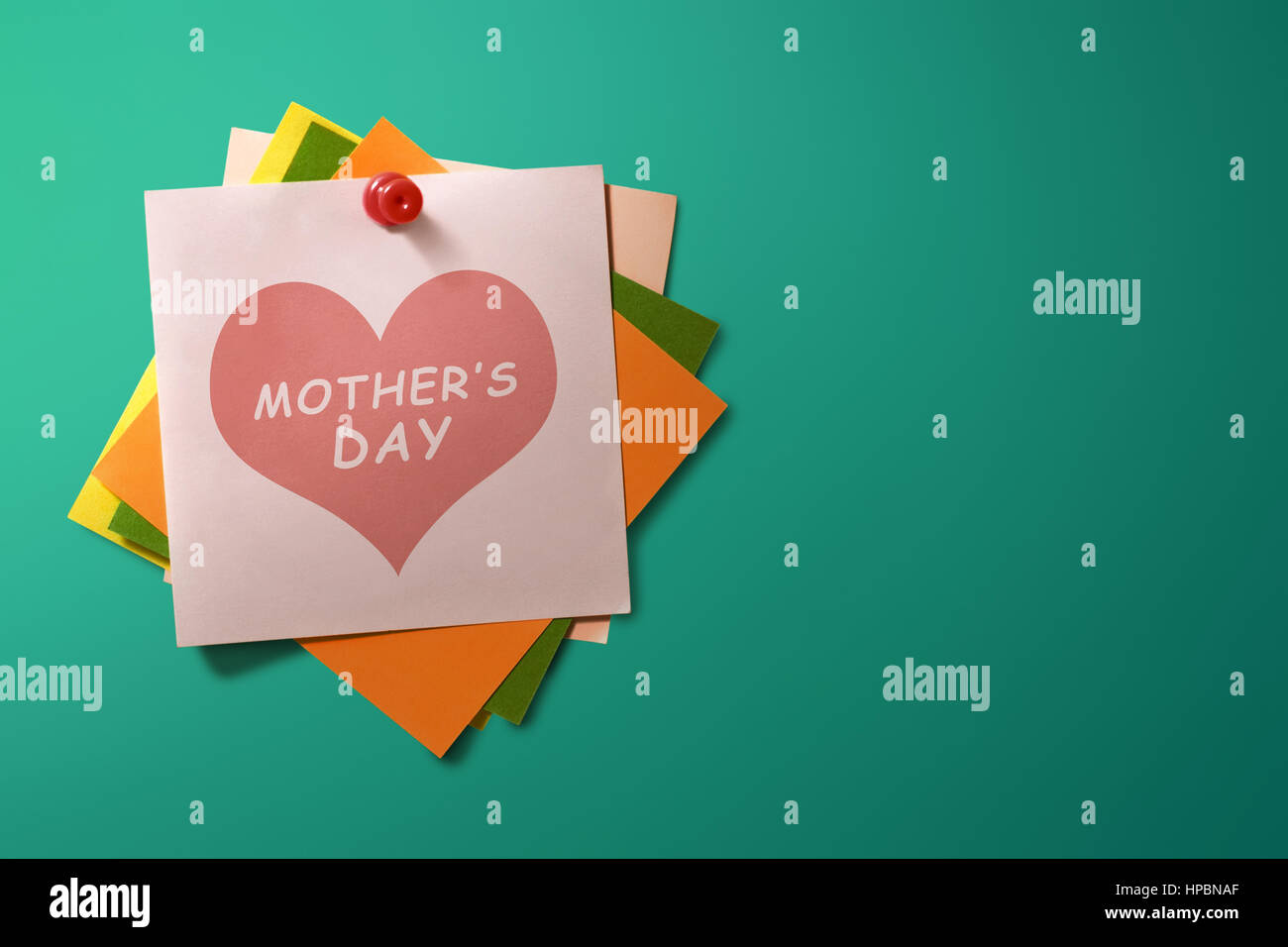 Mothers Day message written on stack of colorful paper note on green ...