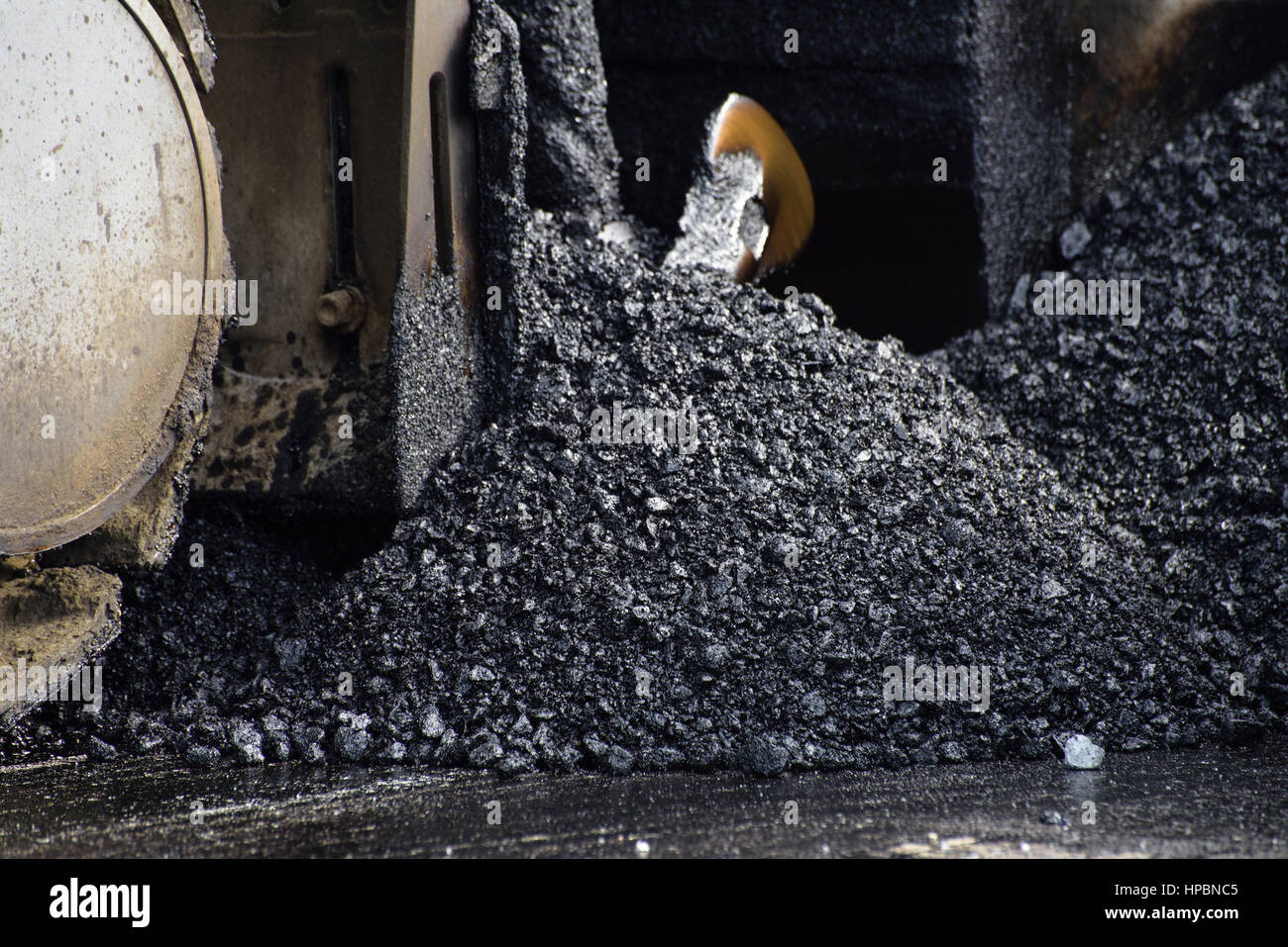 closeup hot asphalt gush out of asphalt paver machine Stock Photo - Alamy