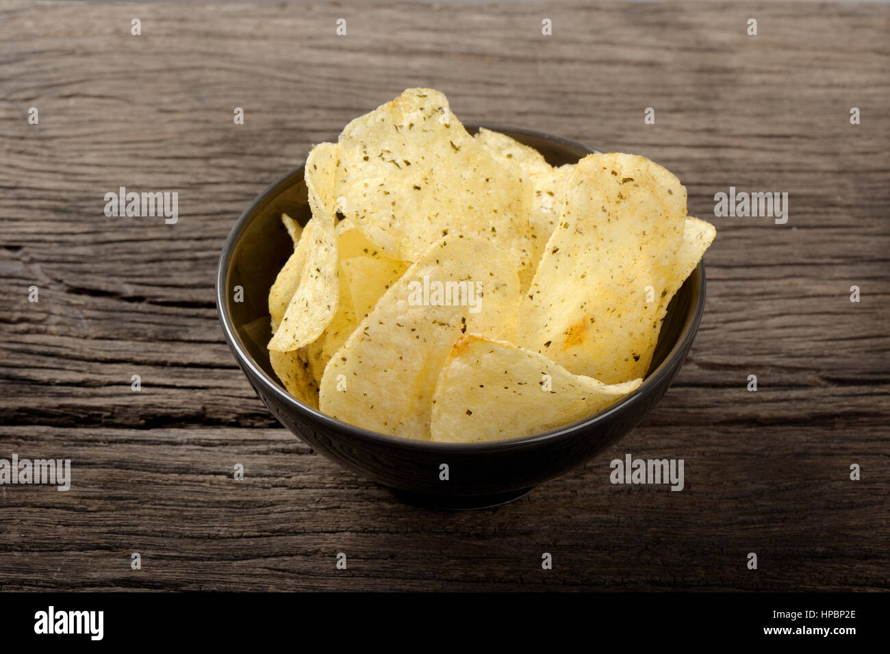 closeup potato chips in bowl on wooden desk Stock Photo - Alamy