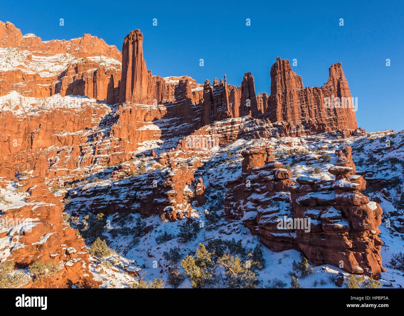 Rock fins rise above the a snowy canyon at the Fisher Towers rock ...
