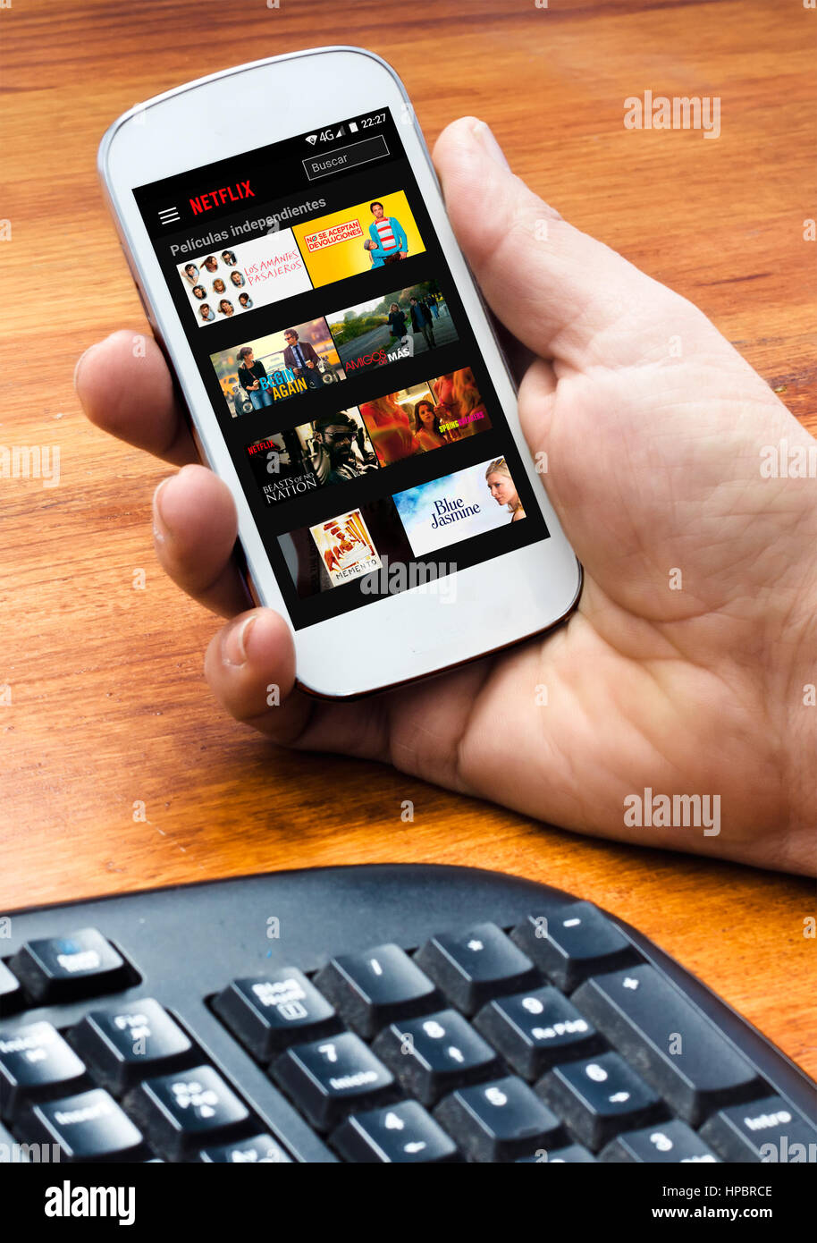 Close-up of man's hand holding cell with netflix application on screen ...