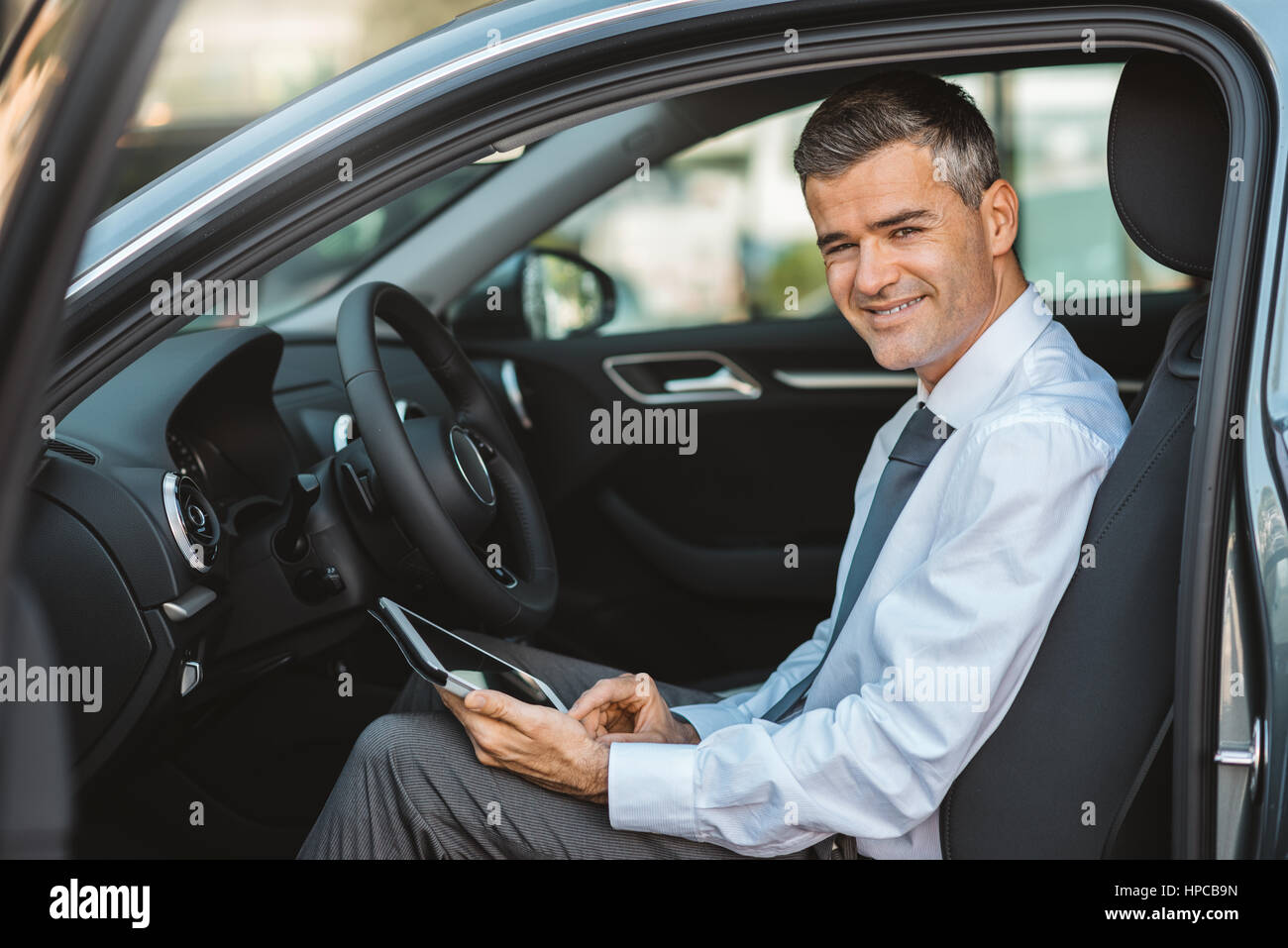 Businessman traveling by car and navigating with his touch screen ...