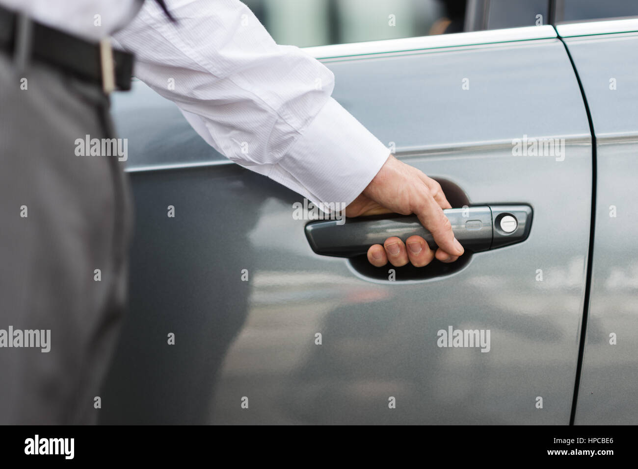 Businessman opening a car door, hand on handle close up, business and ...