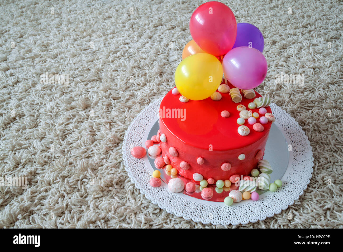 Homemade red birthday cake with air baloons Stock Photo - Alamy