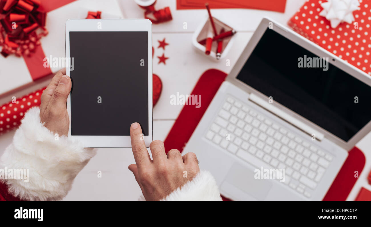 High tech Santa Claus preparing for Christmas, he is working at desk ...