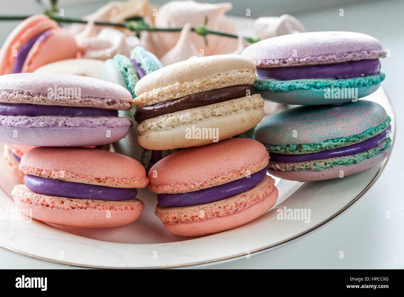 Sweet and colorful french macaroons or macaron in ceramic white plate ...