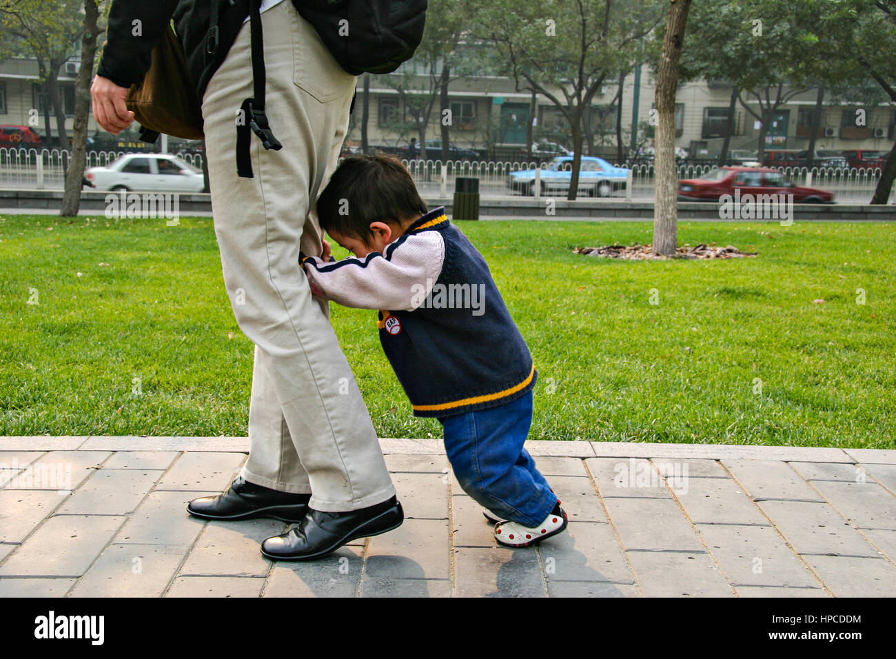 A toddler boy pushing his mother moving forward Stock Photo - Alamy