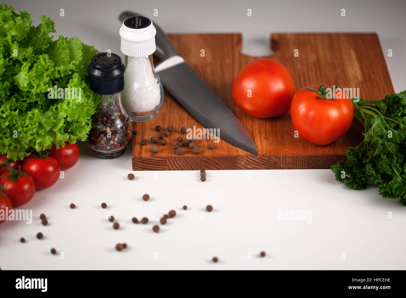 Close-up working surface with wooden cutting board, chef's knife and ...
