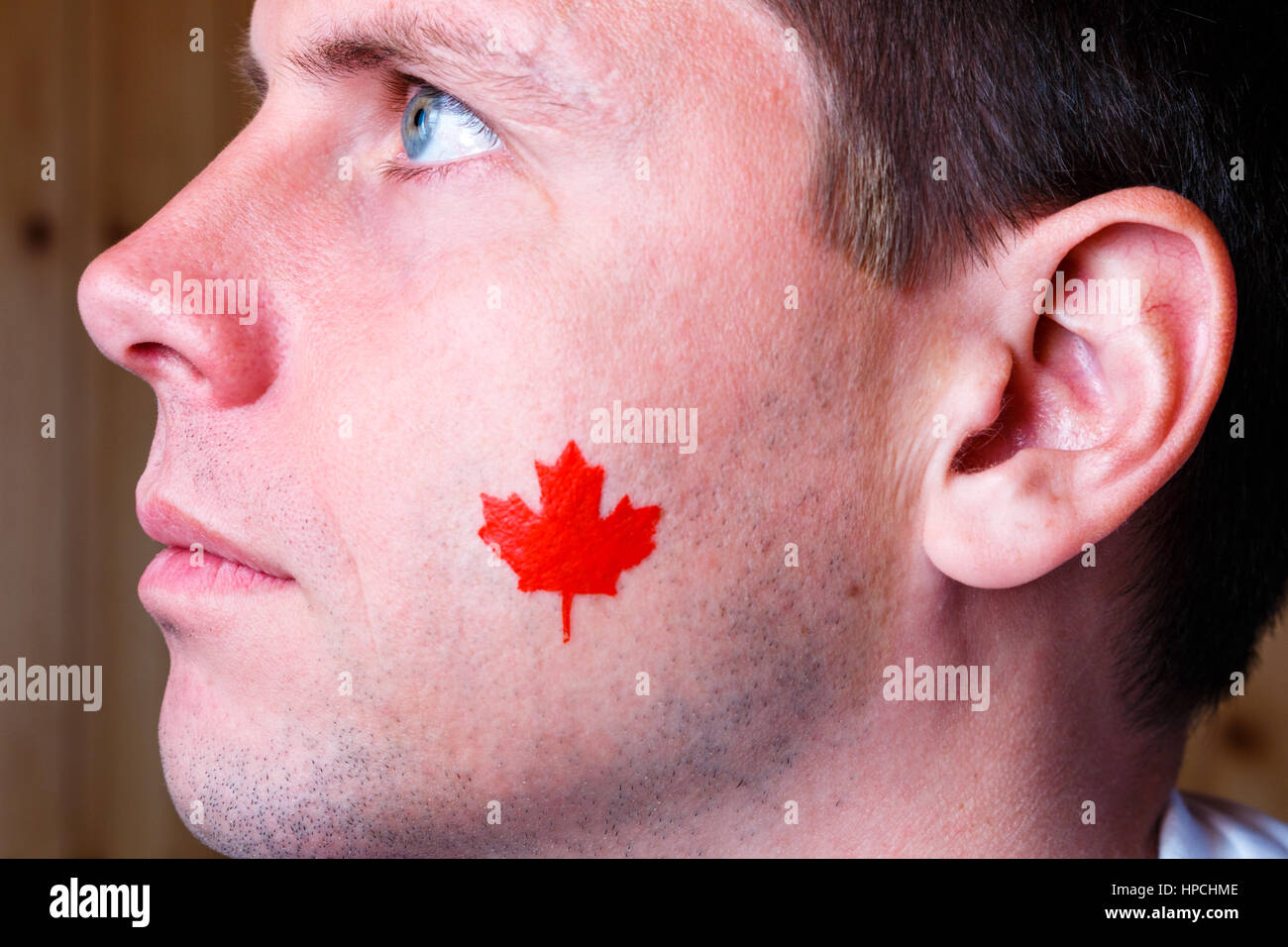 canadian flag on the face of young man Stock Photo - Alamy