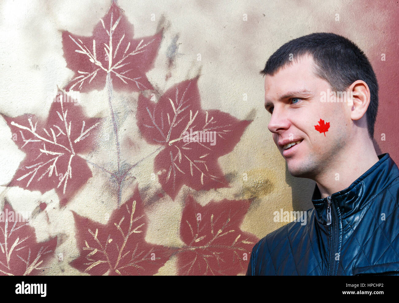 canadian flag on the face of young man Stock Photo - Alamy