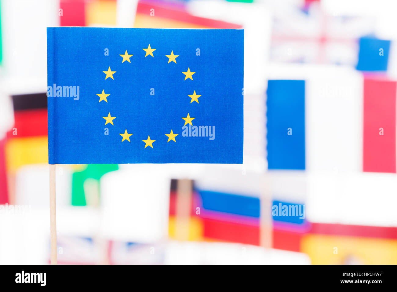 Close-up picture of small paper flag of European Union against flags of ...