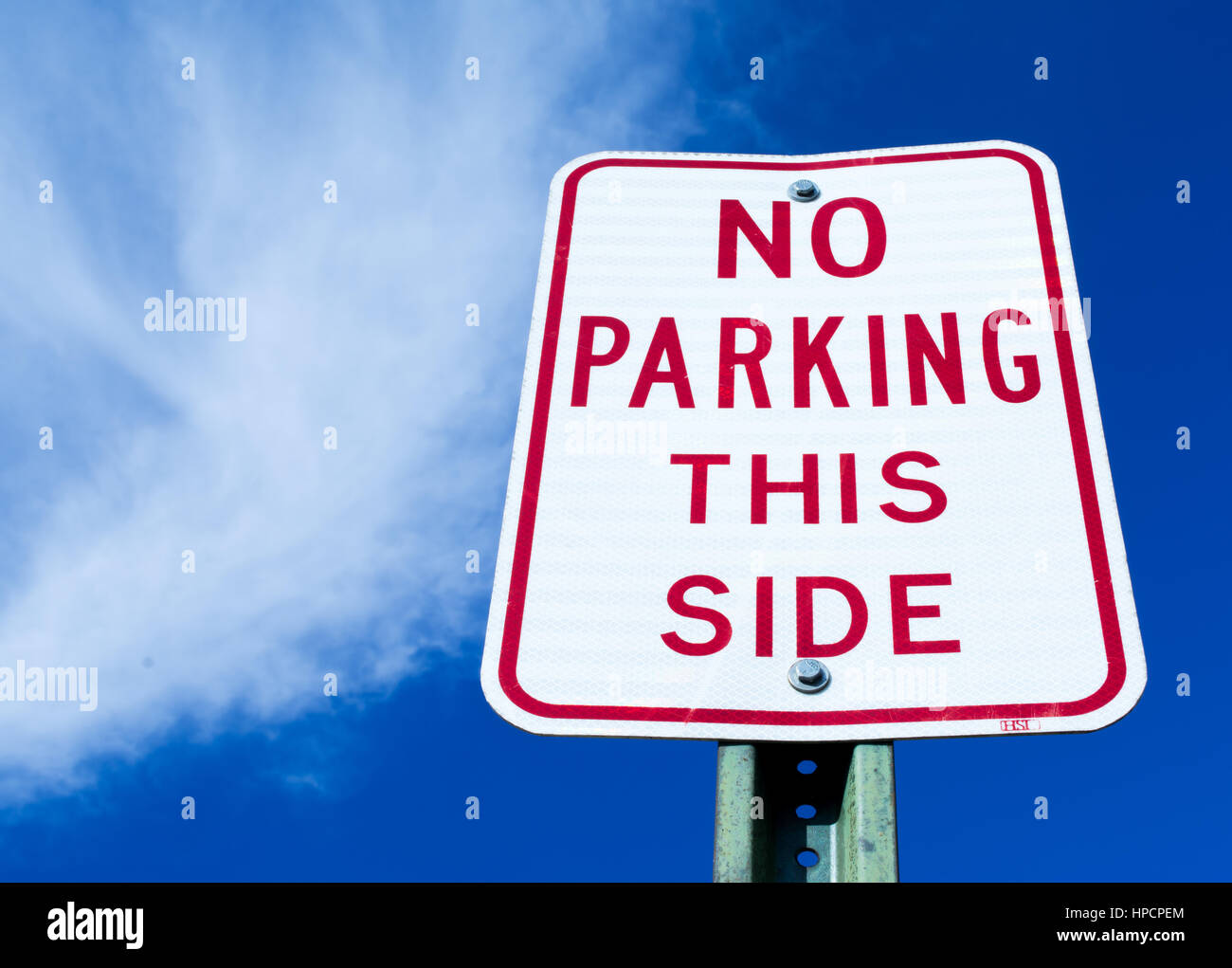 'No parking this side' sign against vibrant blue sky Stock Photo - Alamy