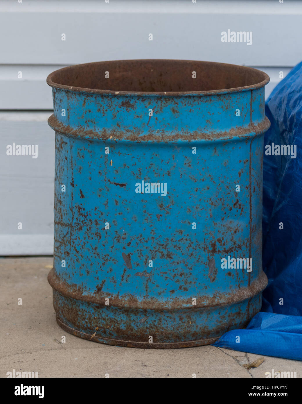 Rusty Blue Bin sitting on sidewalk in industrial district Stock Photo ...