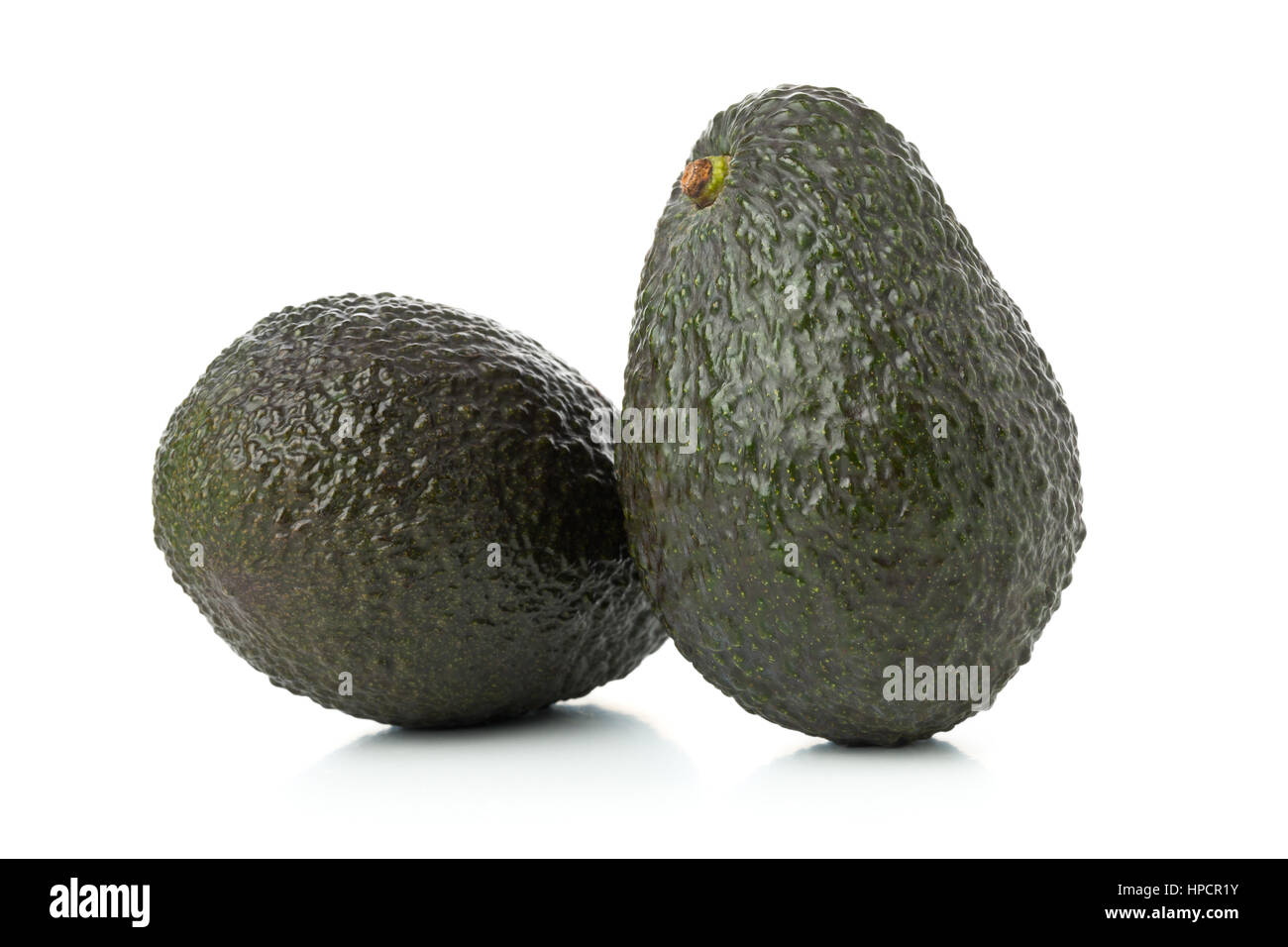 Two whole, uncut ripe avocado fruit on white background Stock Photo - Alamy